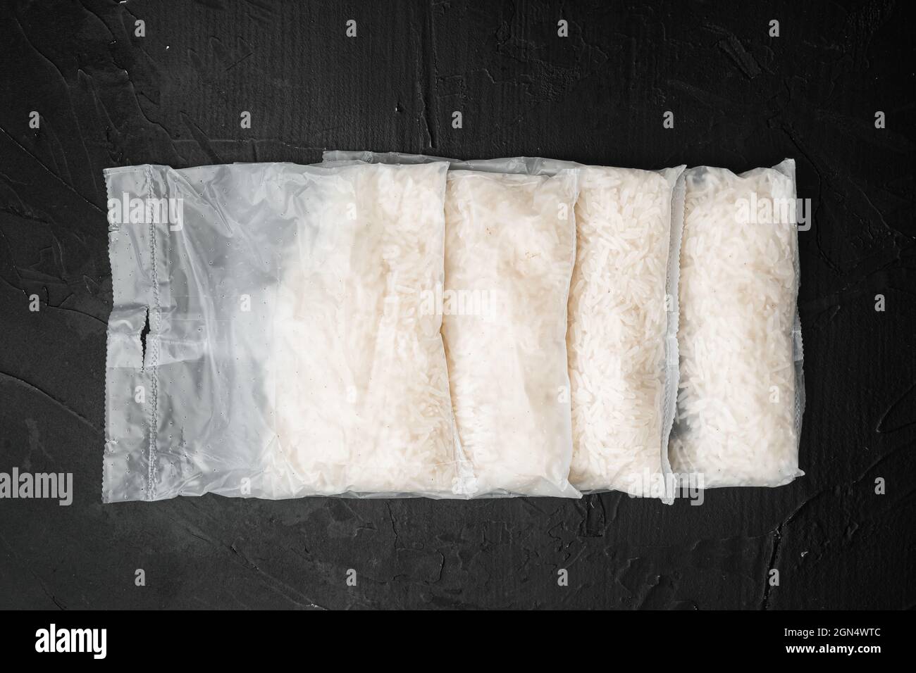 Rice in portion bags set, on black dark stone table background, top ...
