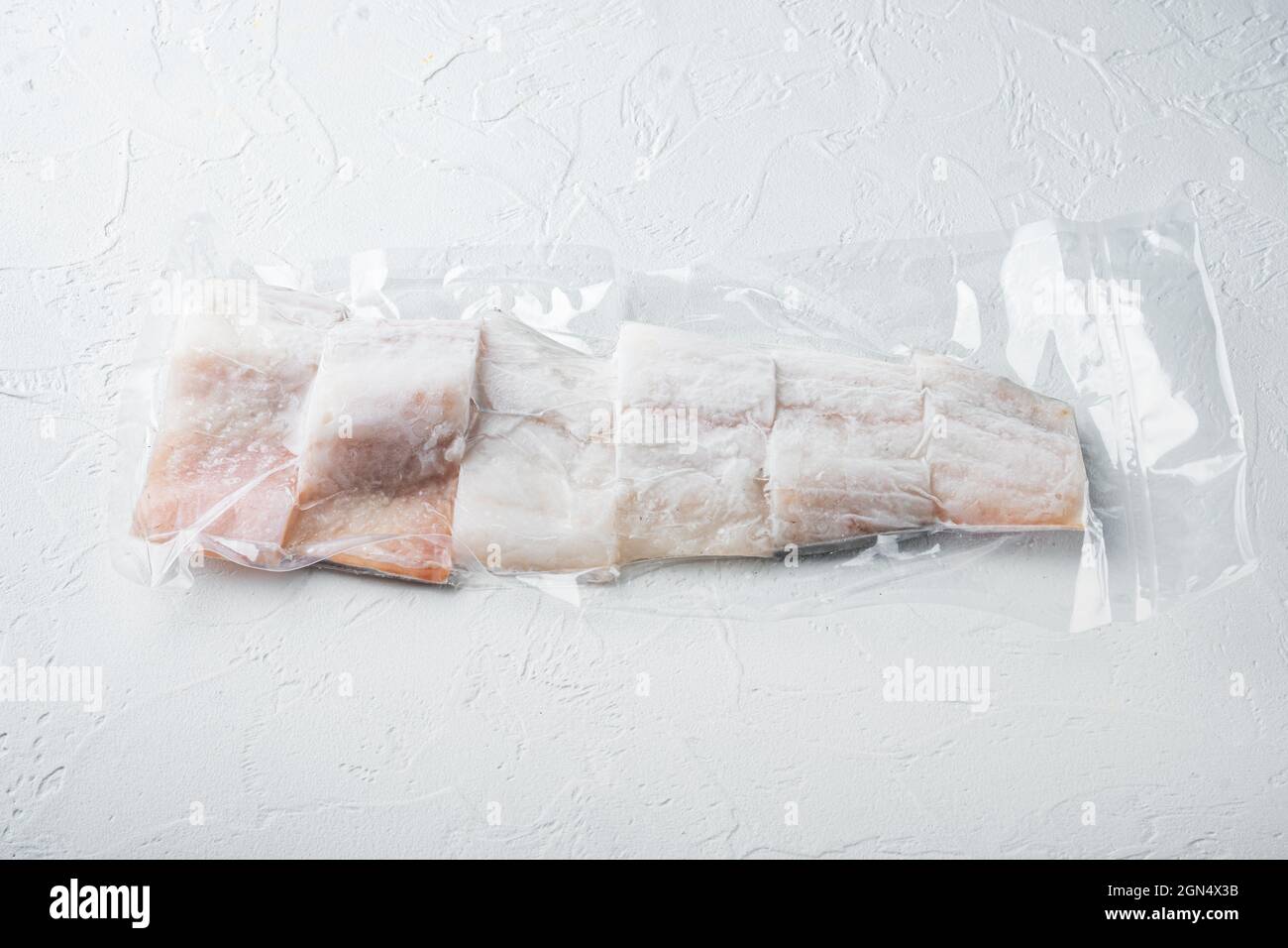 Haddock fish skinless in vacuum package, on white background with copy ...