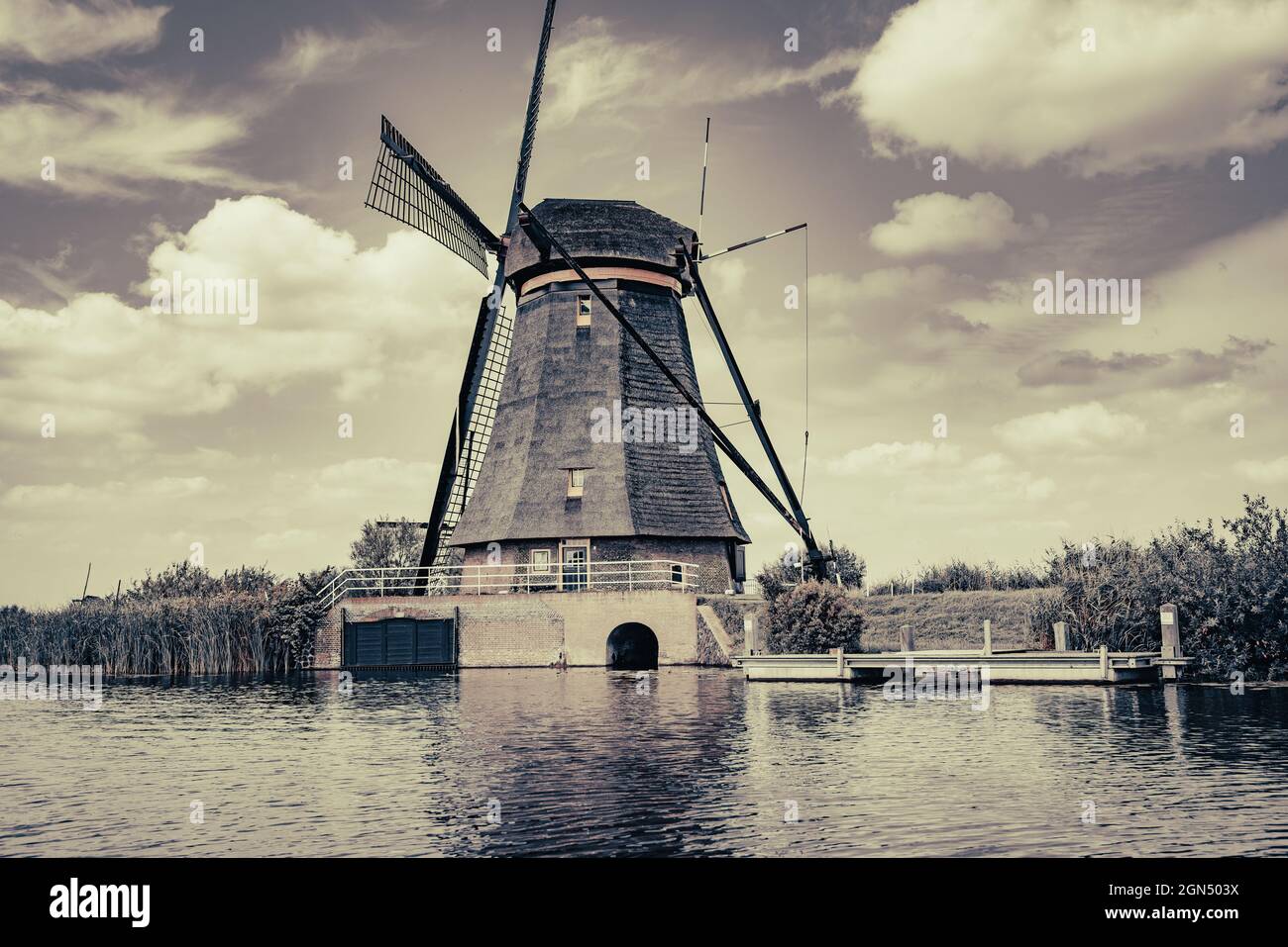 Traditional Dutch windmill in old-fashioned effect with dramatic cloudy ...