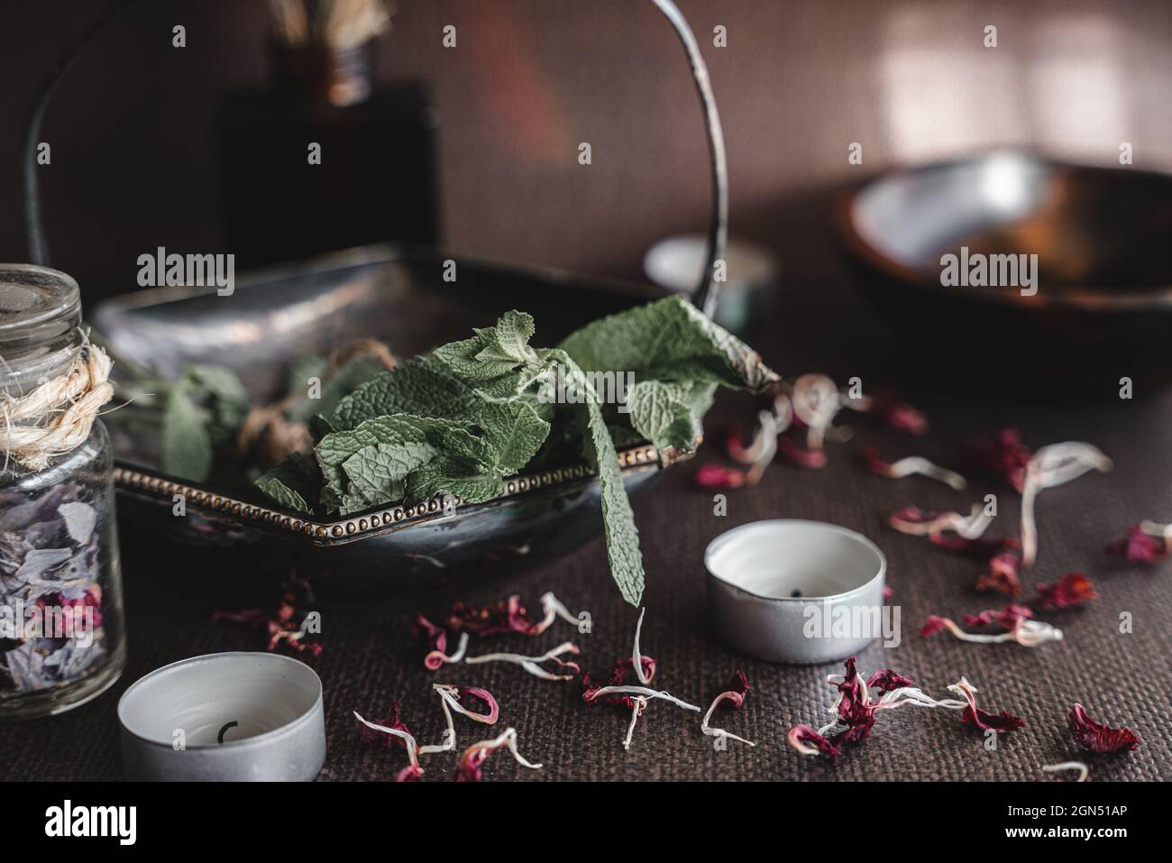 Bunch of fresh mint in a metal rustic vintage old bowl on a wiccan ...