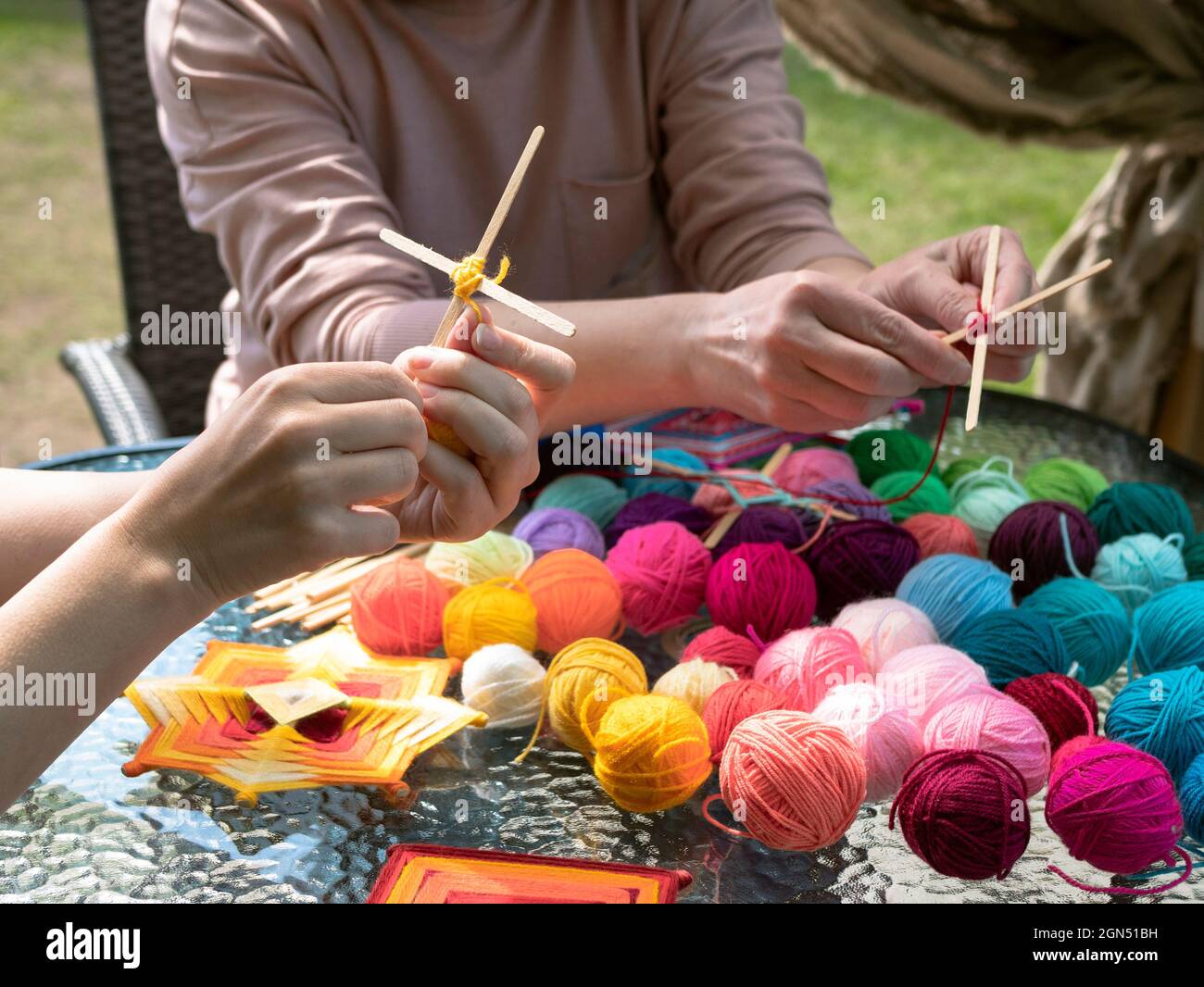 Master-class in mandala weaving, close up. Woman is teaching another ...