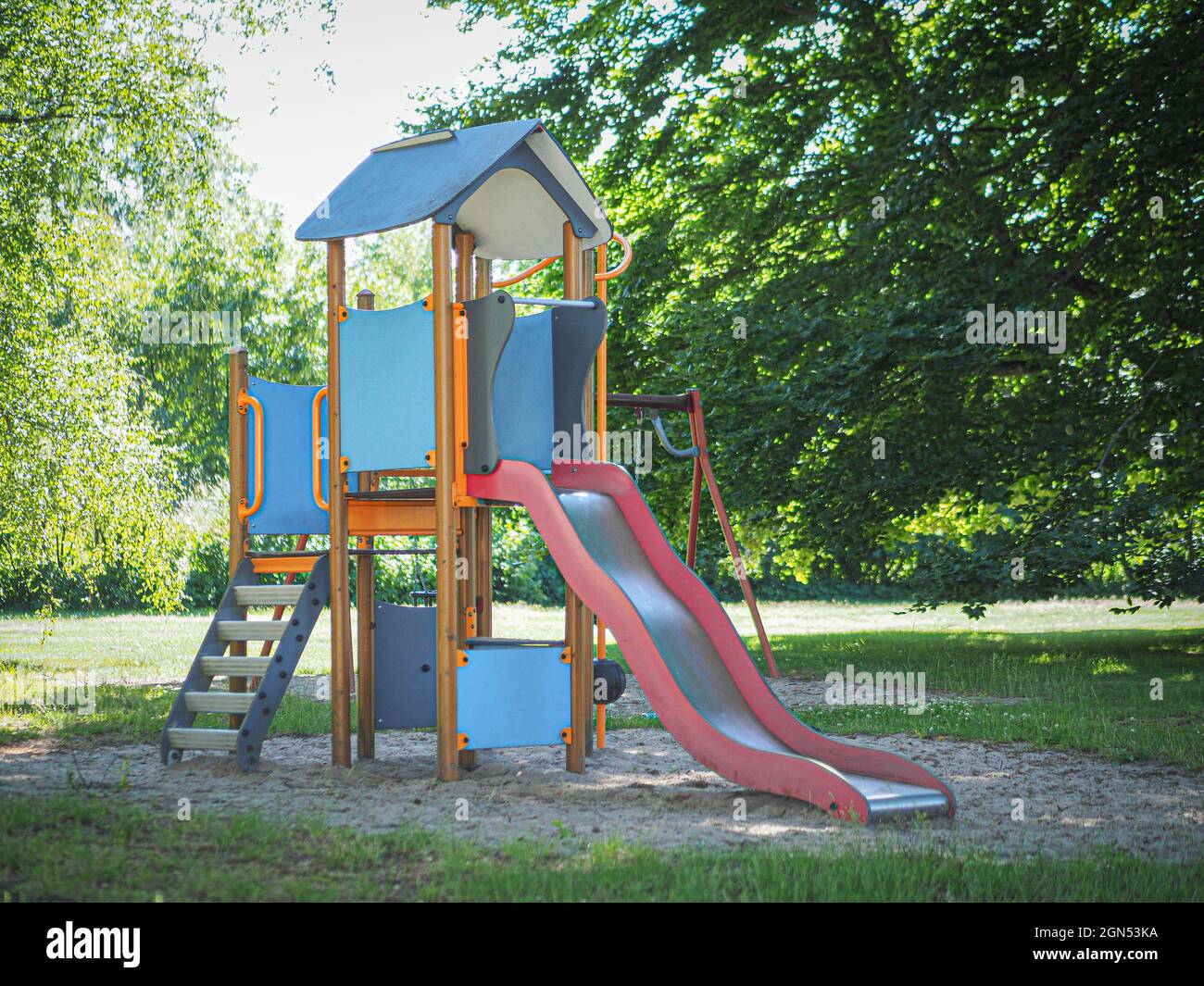 Colorful playground slide with the trees at the background Stock Photo ...