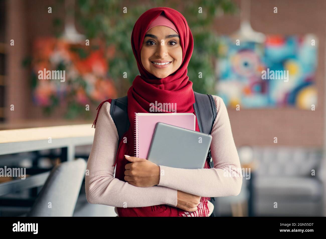 Cheerful muslim woman student with backpack and books at cafe Stock ...