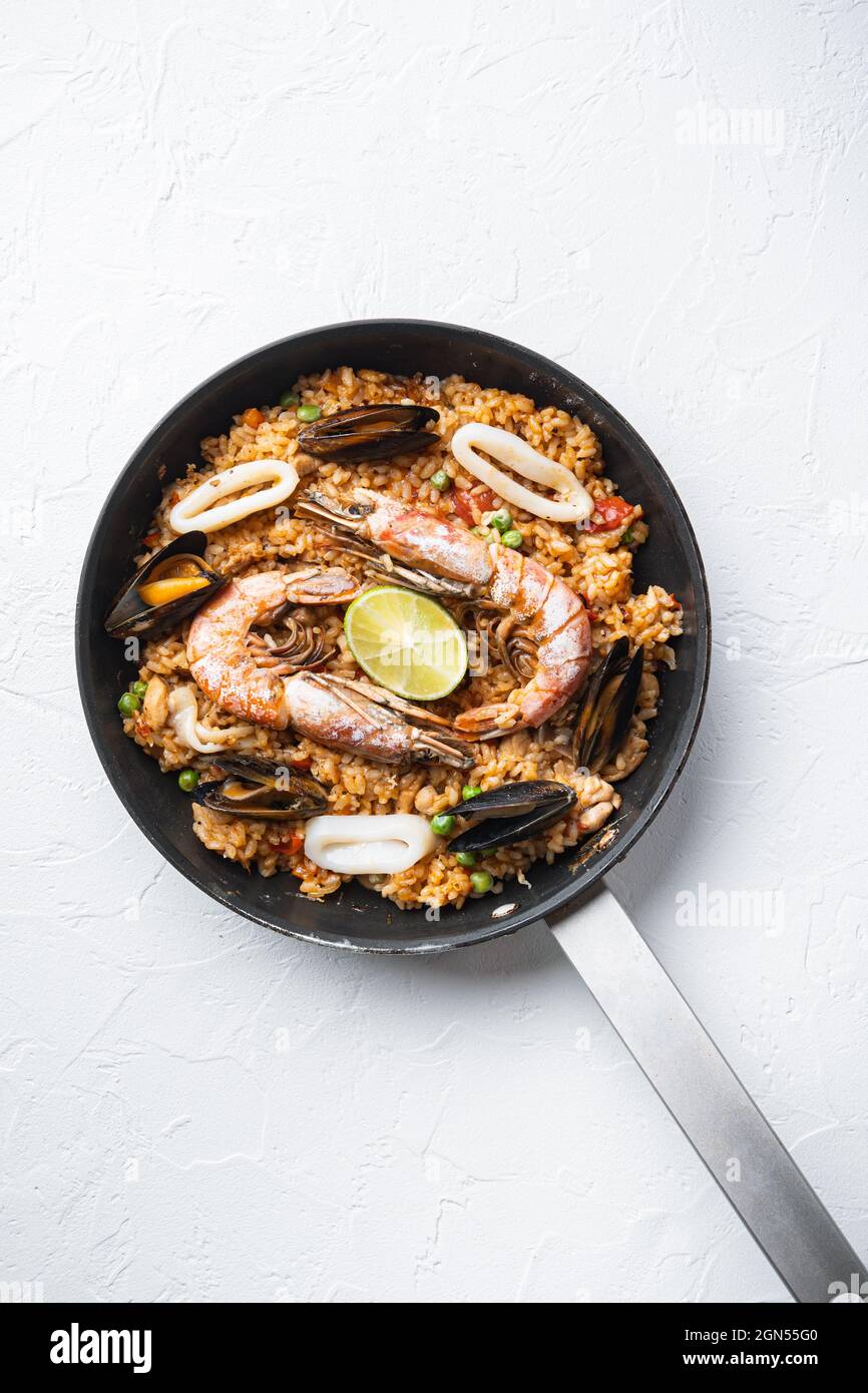 Paella cooked in frying pan on white textured background, flat lay, food photo Stock Photo - Alamy