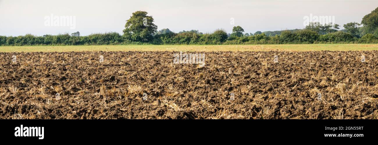 Panorama of heavily ploughed field showing large areas of turned soil ...