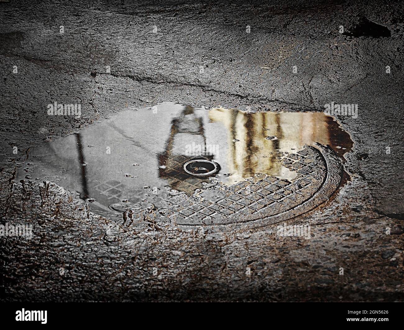 Water puddle on a round metal hatch in the road Stock Photo - Alamy