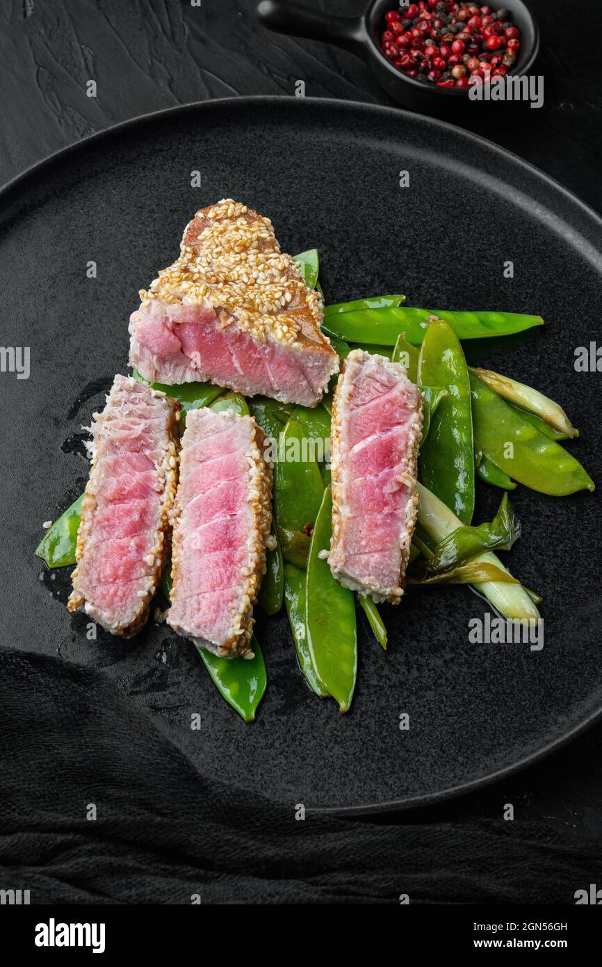 Grilled Ahi Tuna Steak set with spring onions and sugar snap peas, on ...