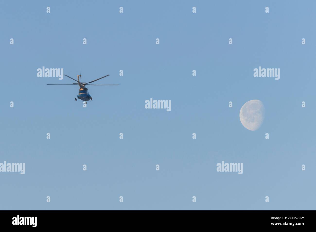 Helicopter flying in the blue sky with moon Stock Photo - Alamy