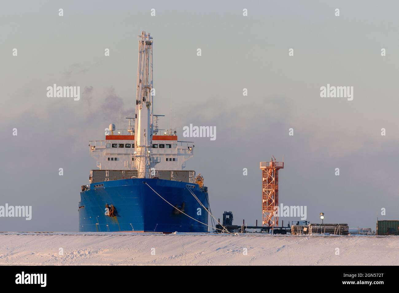 Cargo vessel moored in arctic port. Winter time. Ice navigation ...