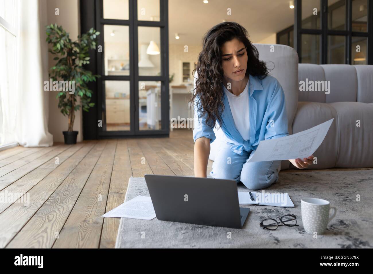 Focused young female freelancer working online, looking through ...