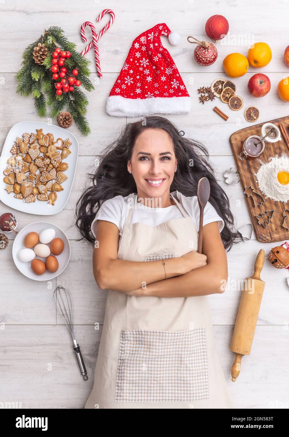 Beautiful dark haired cook laying and widely smiling on the ground ...