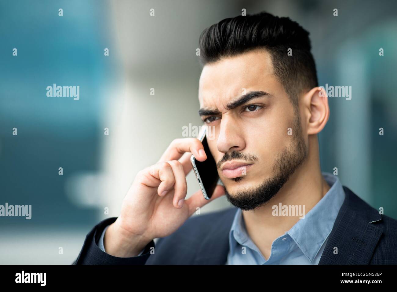 Serious middle-eastern businessman having phone conversation, closeup ...