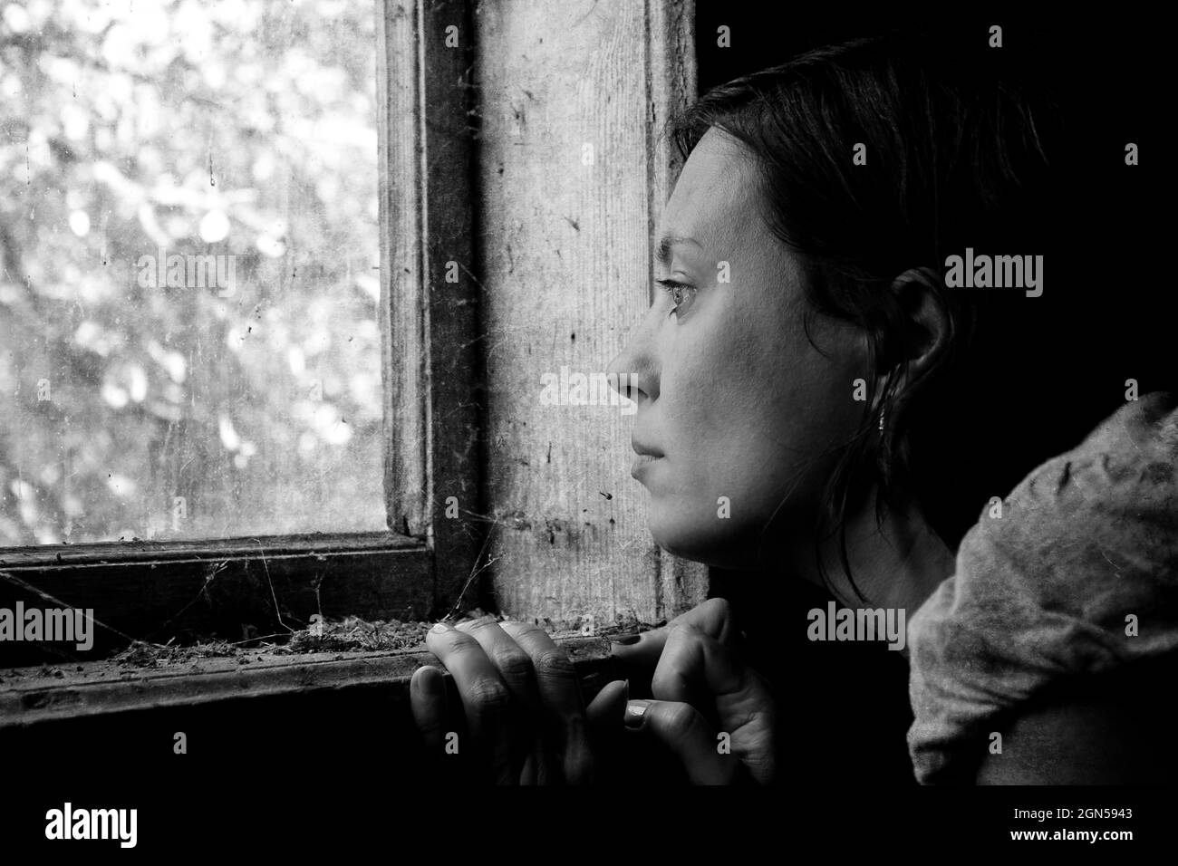 Surreal portrait. Woman looking through the old window. Portrait of a ...