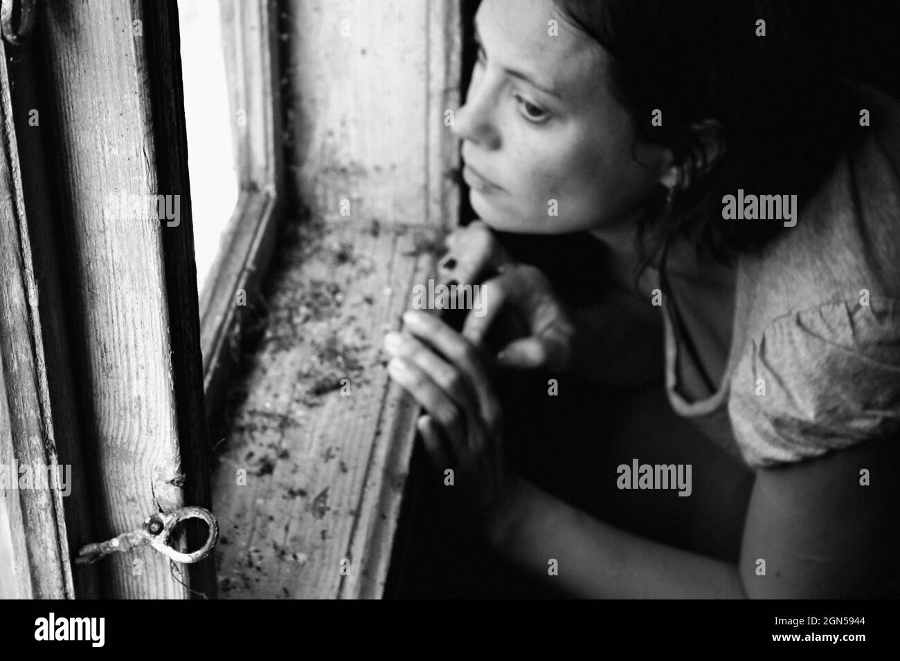Surreal portrait. Woman looking through the old window. Portrait of a ...