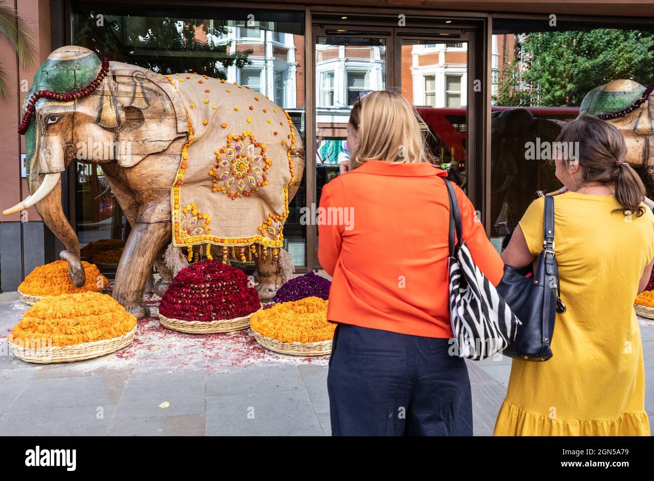 London, UK. 22nd Sep, 2021. Two women look at the two life-sized wooden ...
