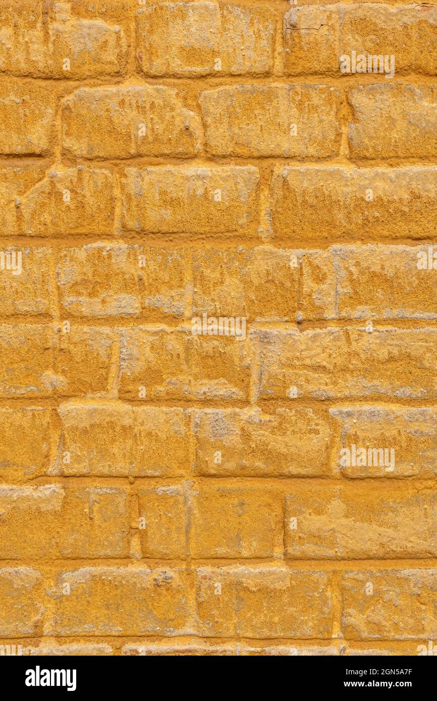Brick and plaster yellow ochre background Stock Photo - Alamy