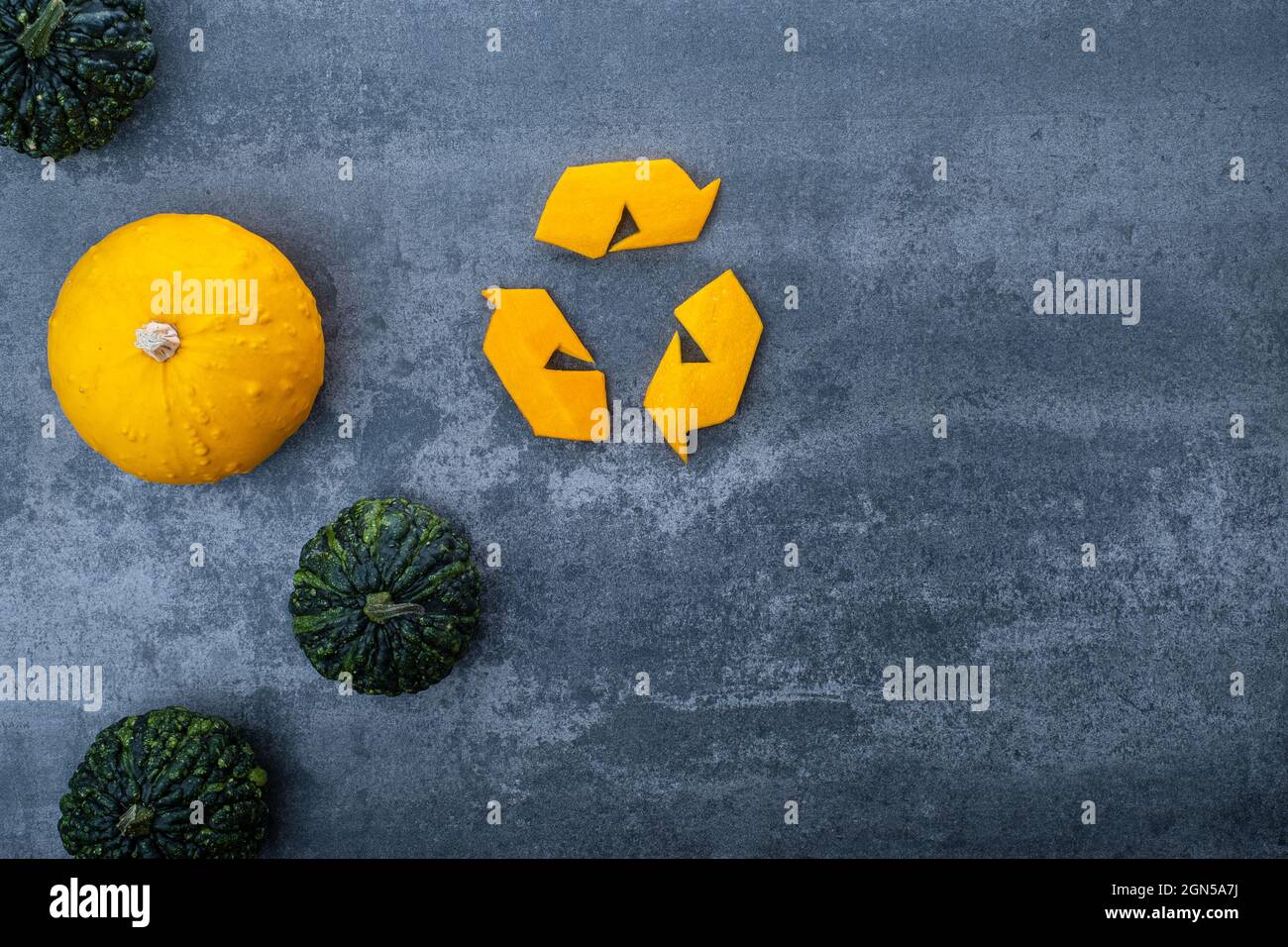 Recycling sign made yellow pumpkin peel on gray background. Top view ...