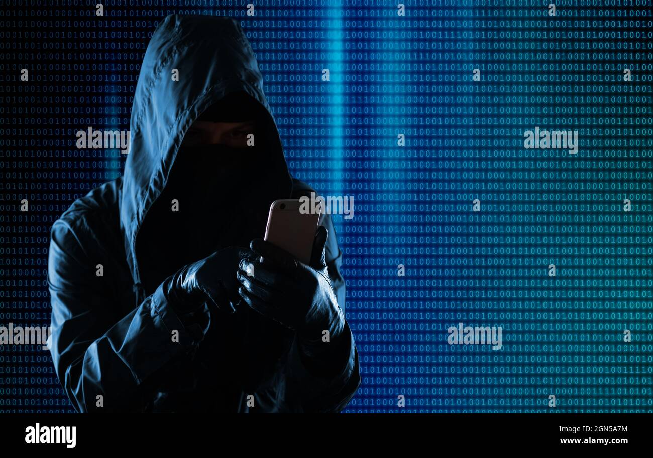Hooded cyber crime hacker using mobile phone internet hacking in to ...