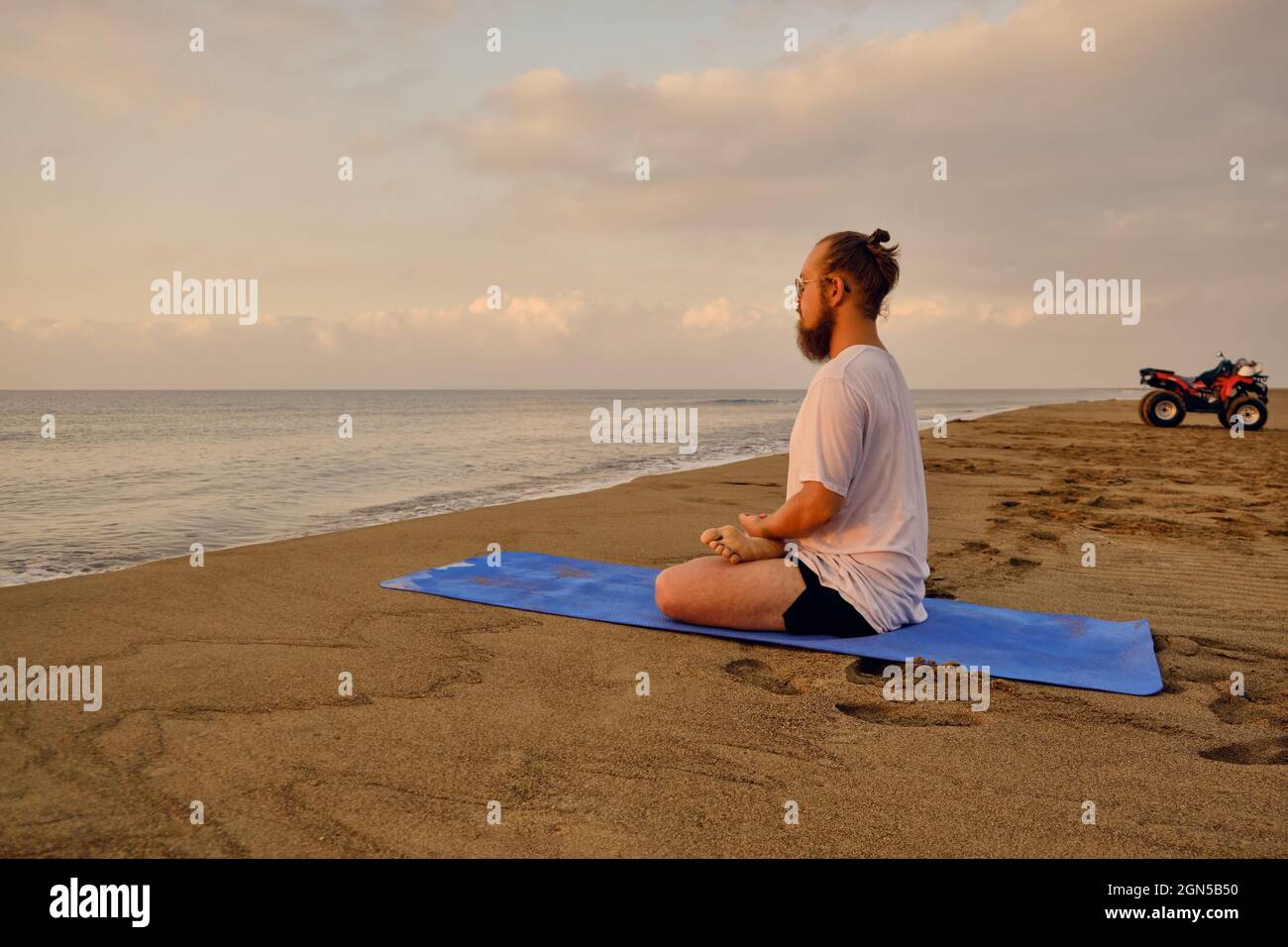 Man meditating at beach Stock Photo - Alamy