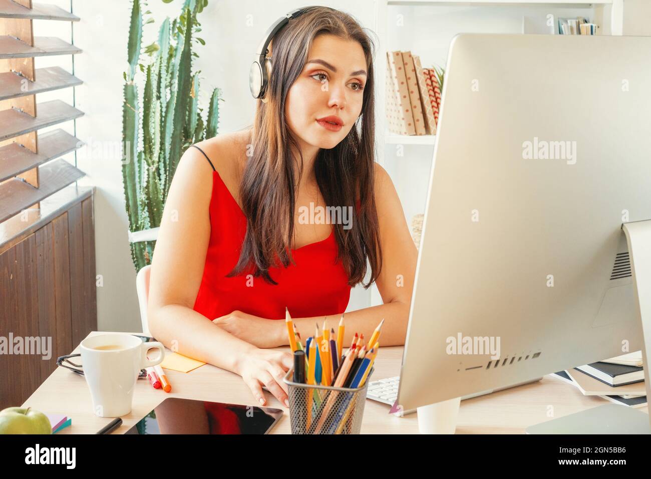 Young woman working in office using computer, sitting at desk Stock ...