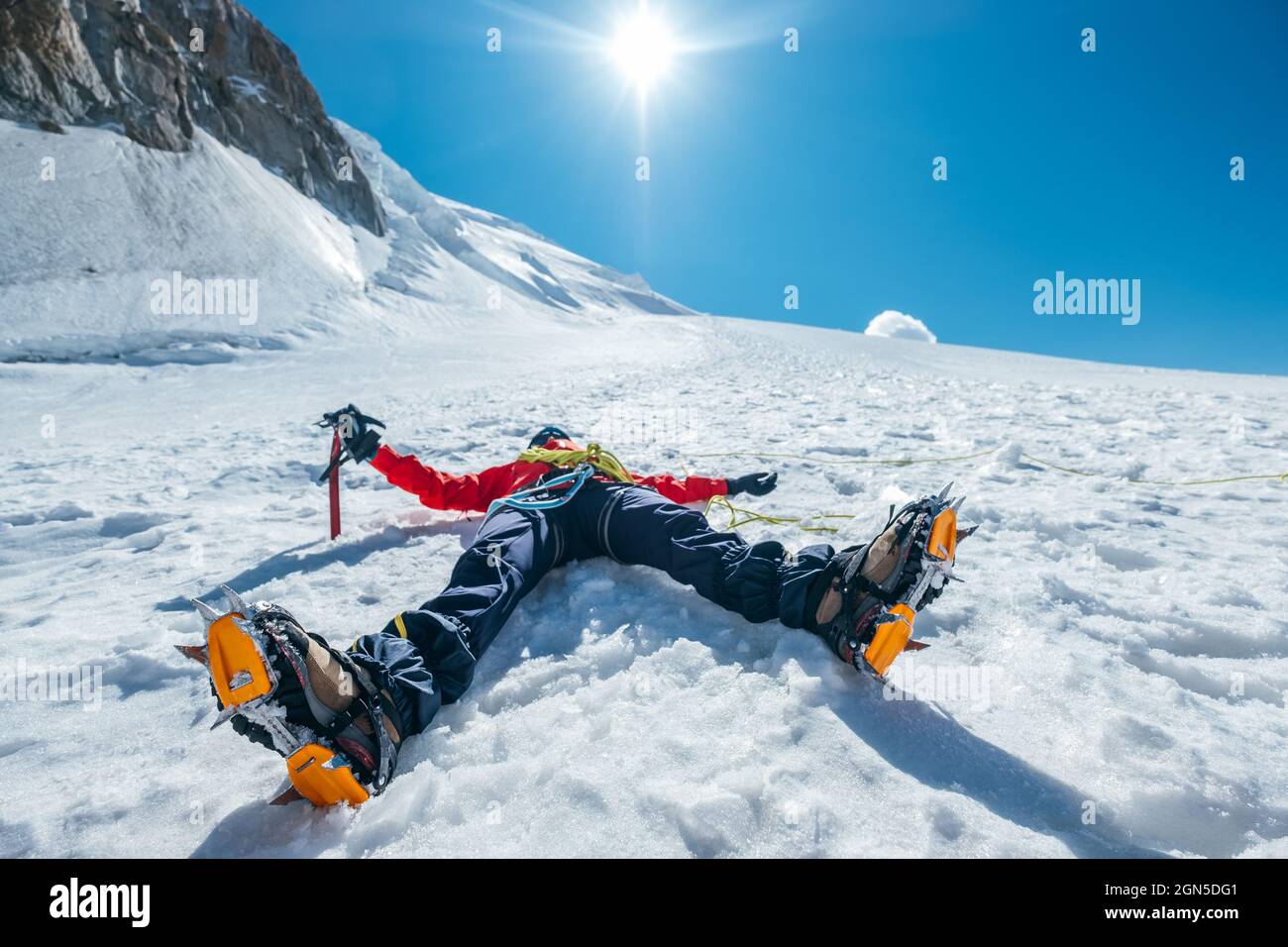 Tired exhausted climber lying under Mont Blanc du Tacul mountain. Wide ...