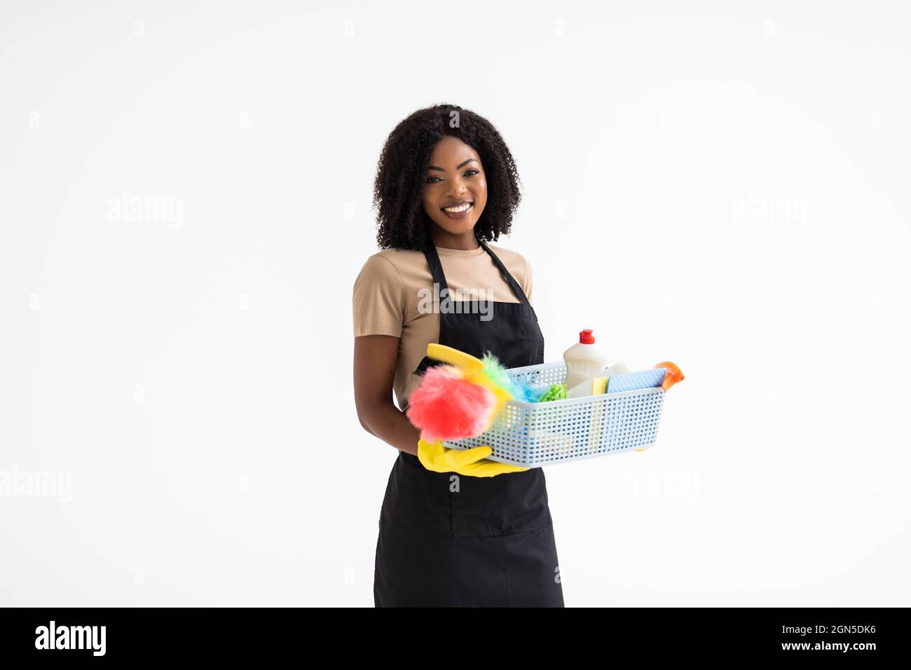 Young african woman housekeeper with detergent tools basket on white ...