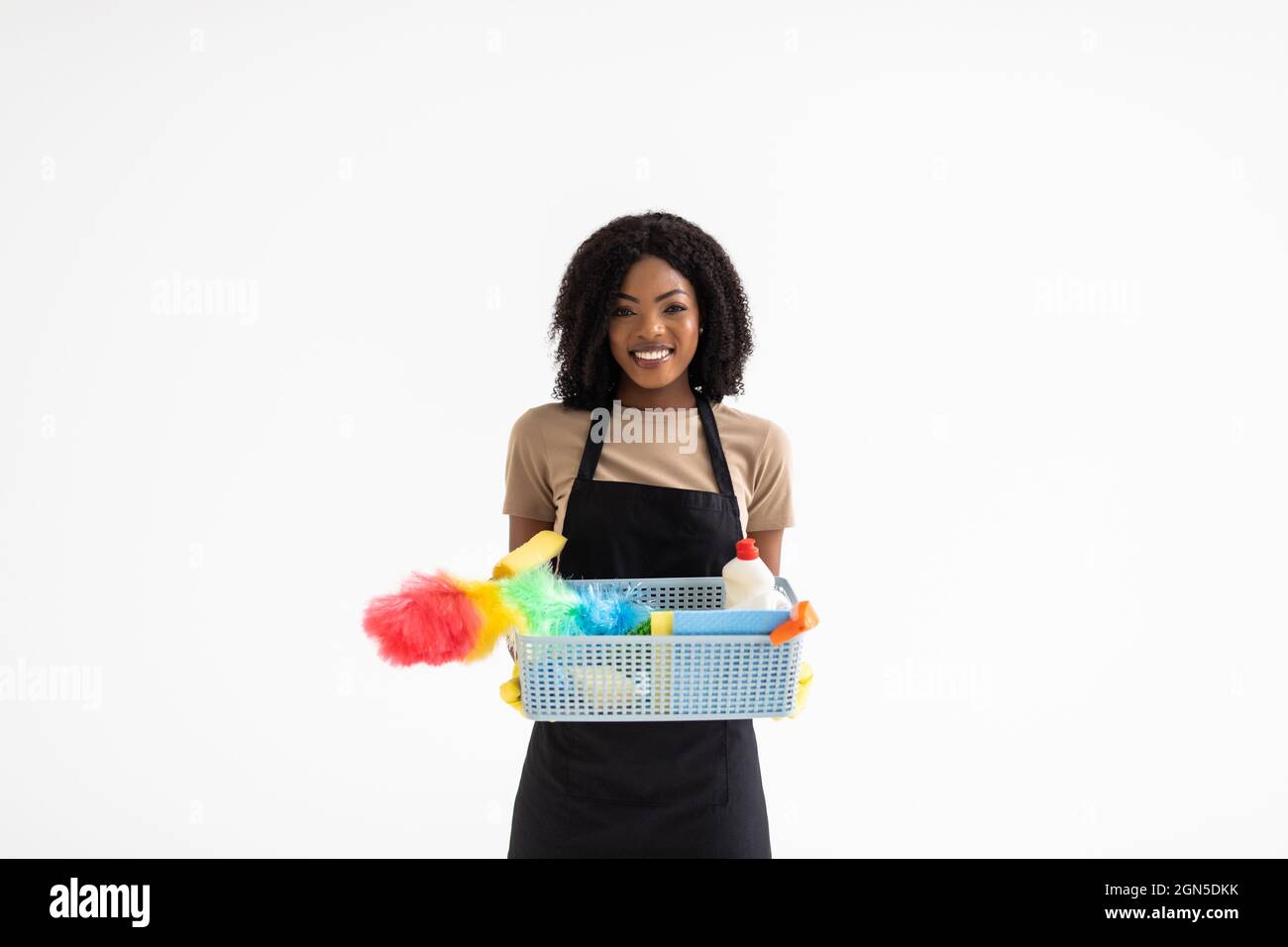 Young african woman housekeeper with detergent tools basket on white ...