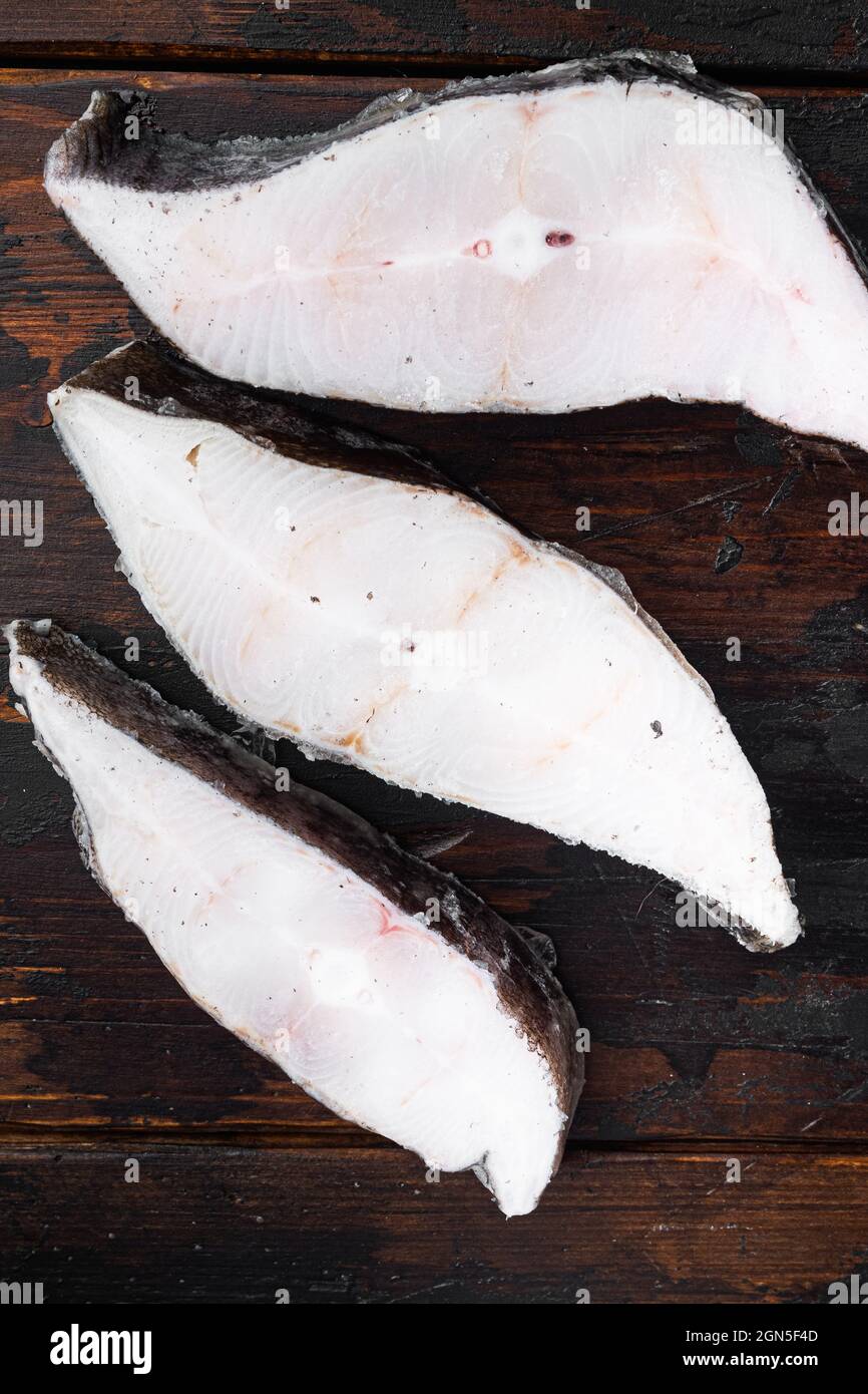 Frozen fish steak set, on old dark wooden table background, top view ...