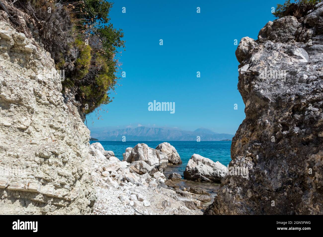 White rocks close-up with Mediterranean greenery and blue clear sky on ...