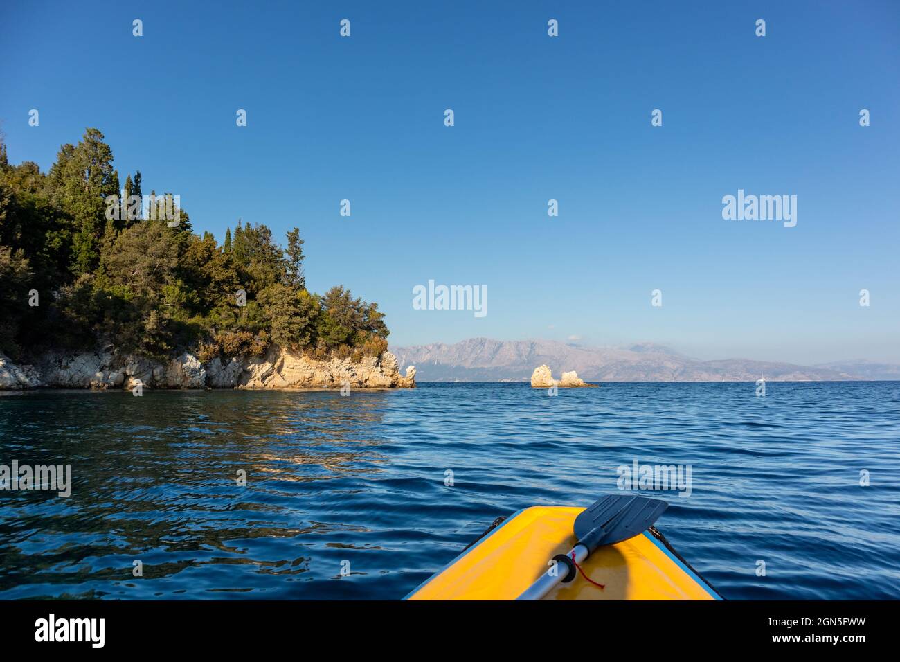 Yellow raft boat and paddle in vivid blue water of Ionian Sea with ...