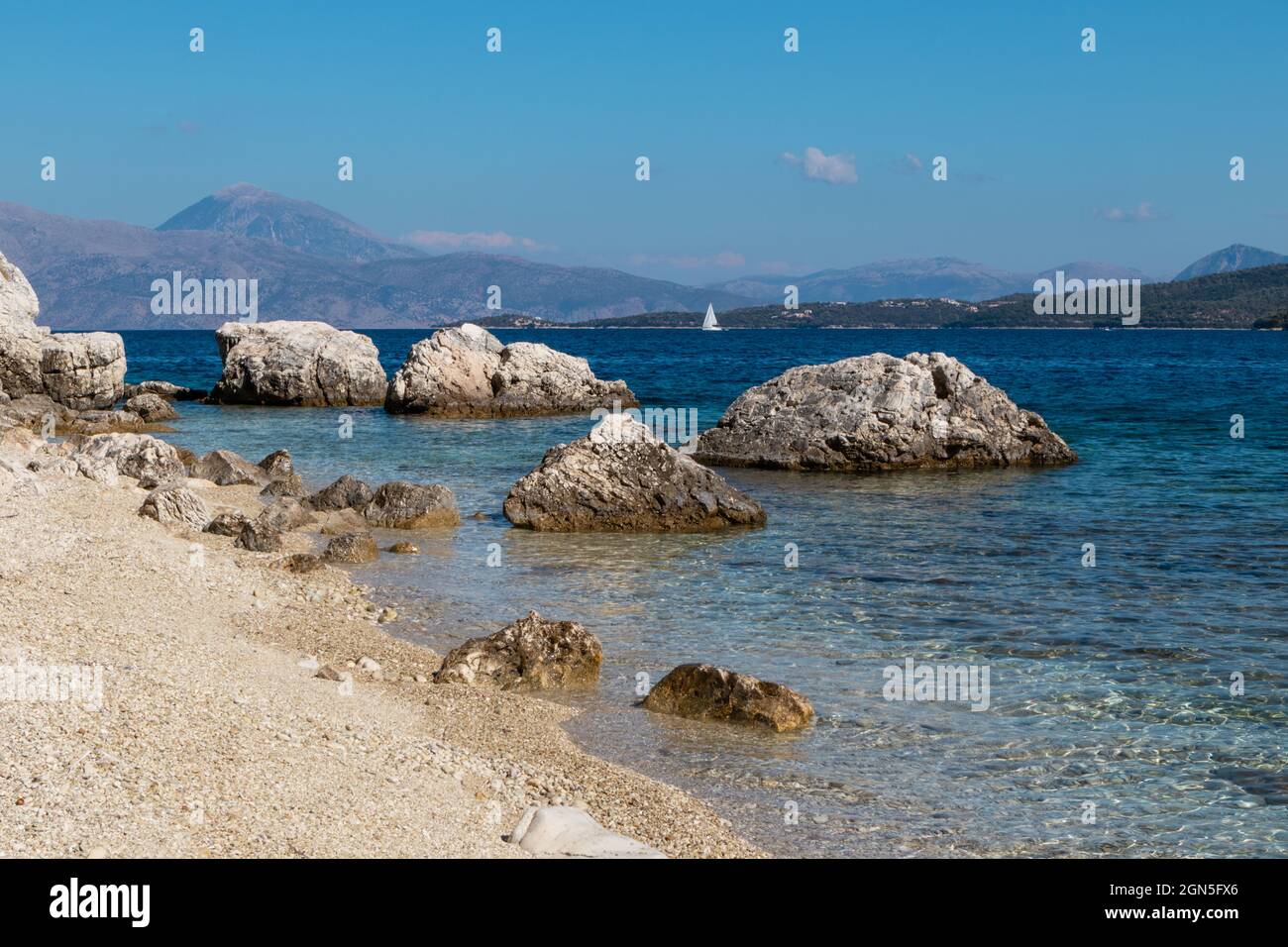 White pebbles and rocks beach with azure clear water on coast of ...
