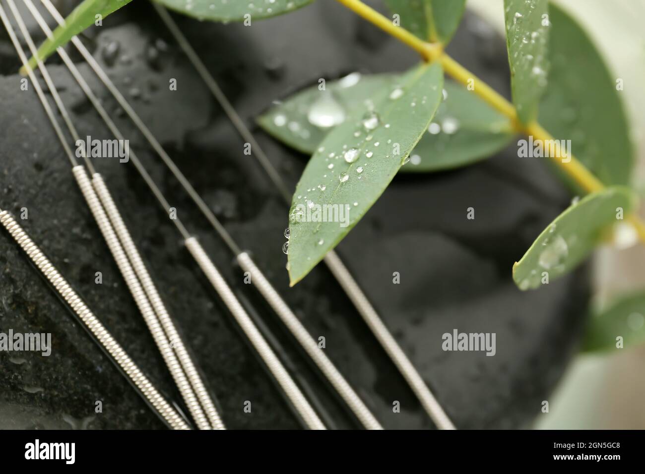 Acupuncture needles and spa stone on water, closeup Stock Photo - Alamy
