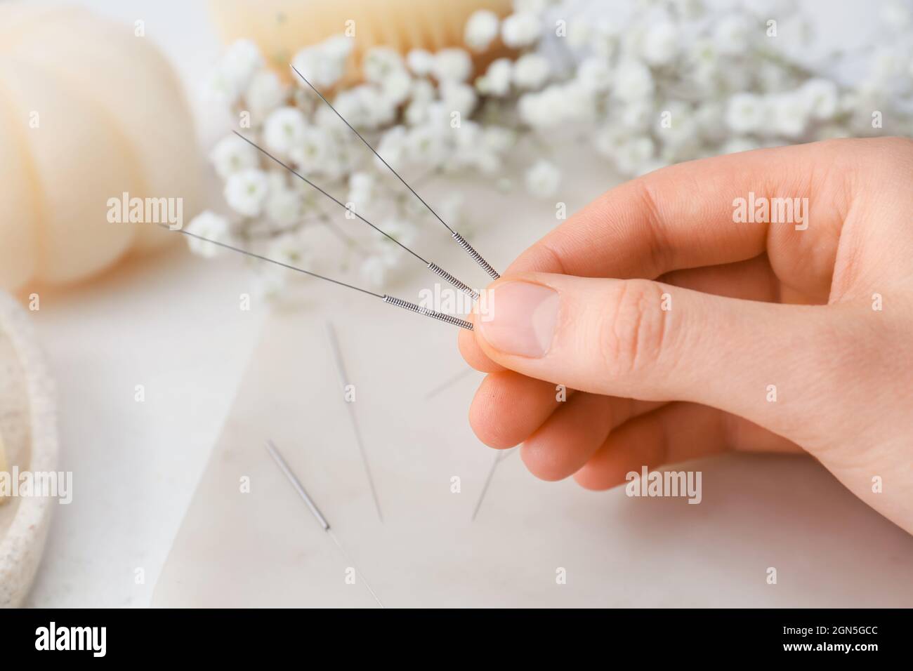 Female hand with acupuncture needles on table Stock Photo - Alamy