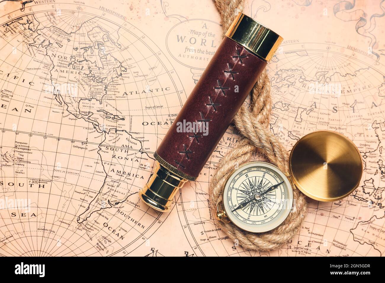 Old spyglass and compass on vintage world map Stock Photo - Alamy