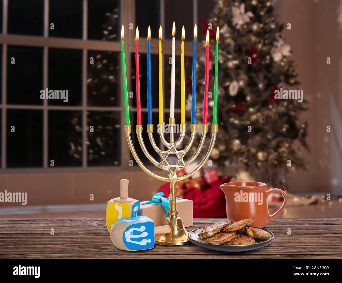 Menorah, potato pancakes and dreidels for Hanukkah on table in room ...