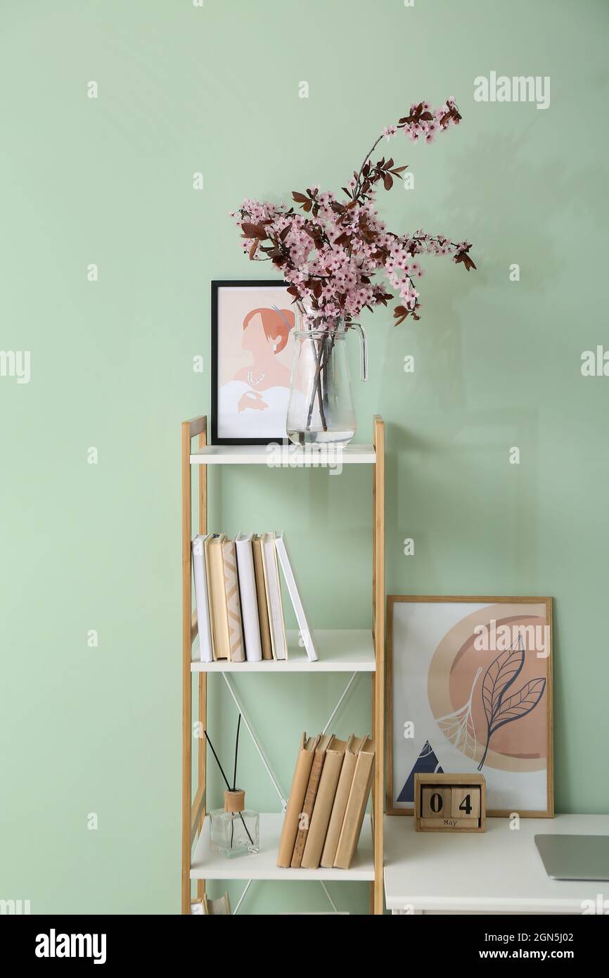 Book shelf with blossoming branches near color wall Stock Photo - Alamy