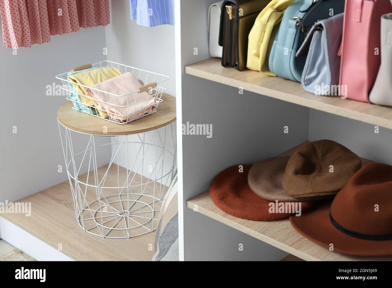 Wardrobe organizer with clothes on table in dressing room Stock Photo ...