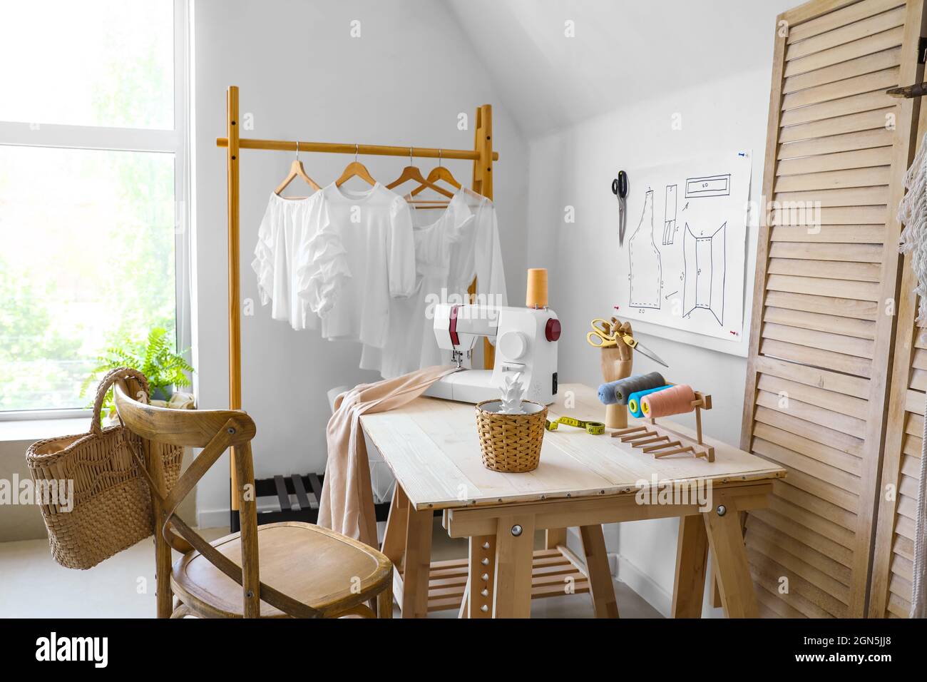 Table with sewing machine and tailor's supplies in atelier Stock Photo ...