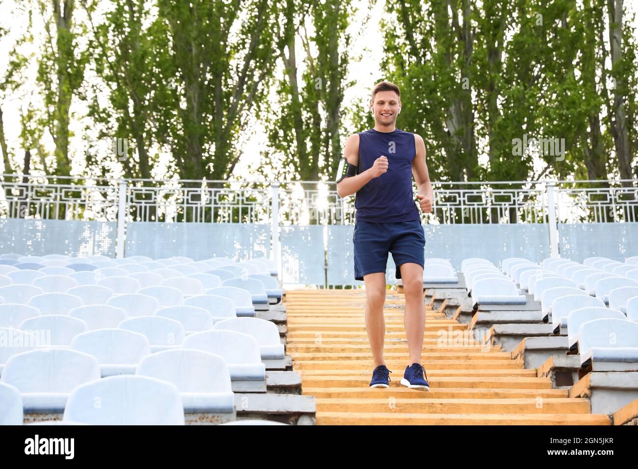 Sporty young man running downstairs at stadium Stock Photo - Alamy
