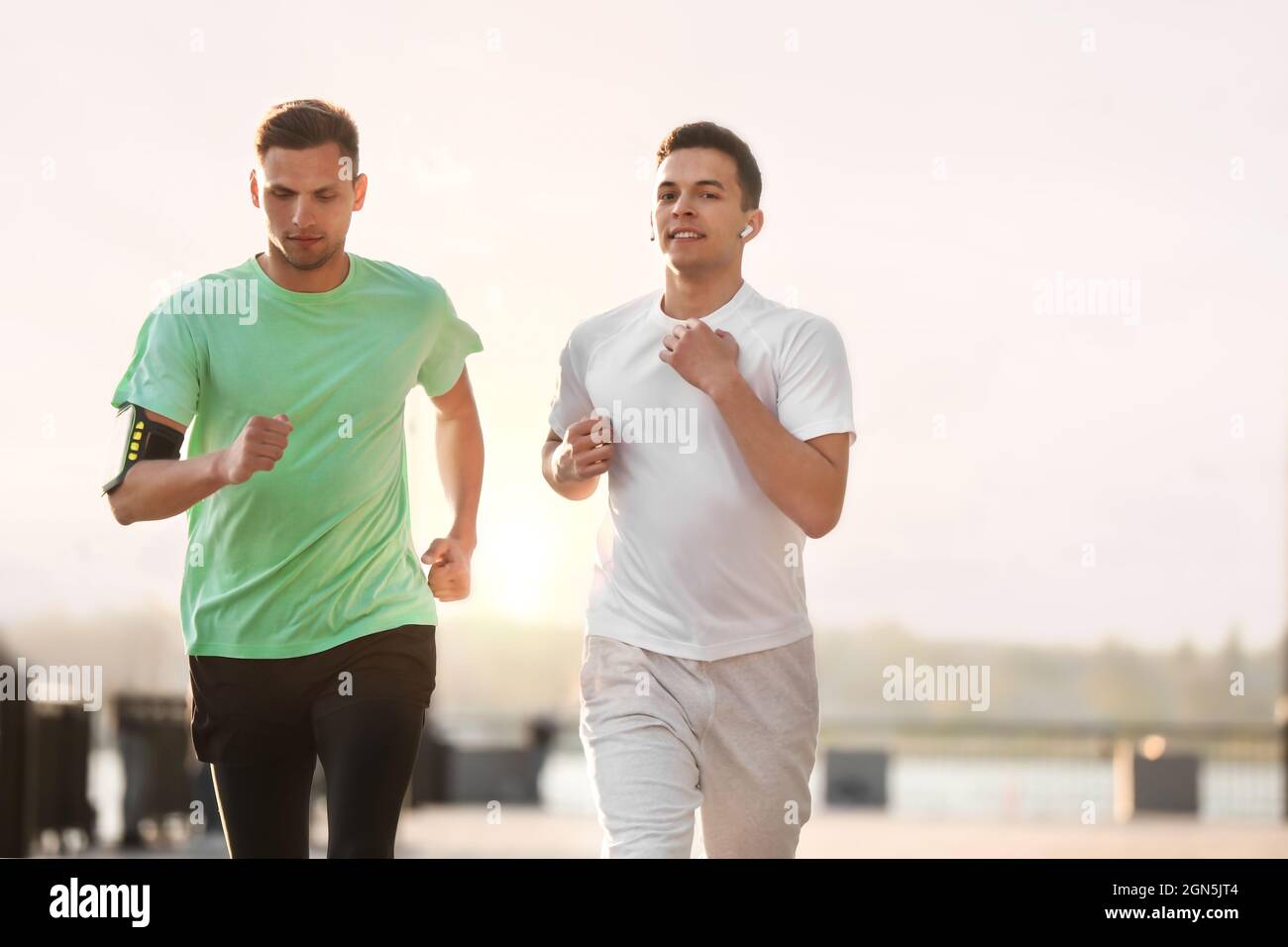 Sporty young men running outdoors Stock Photo - Alamy