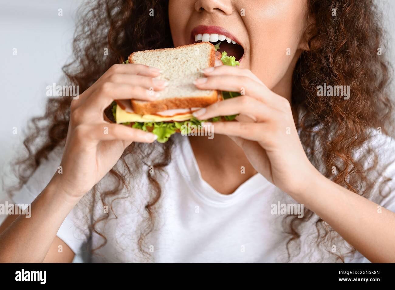 Woman eating bread triangle sandwich hi-res stock photography and ...