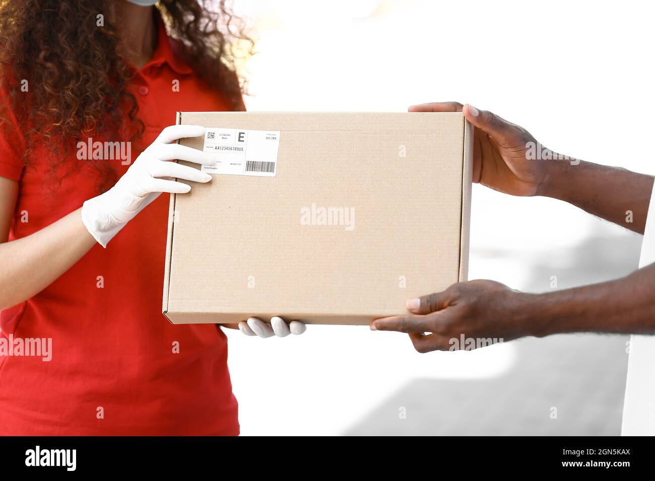 Customer receiving parcel from courier Stock Photo - Alamy