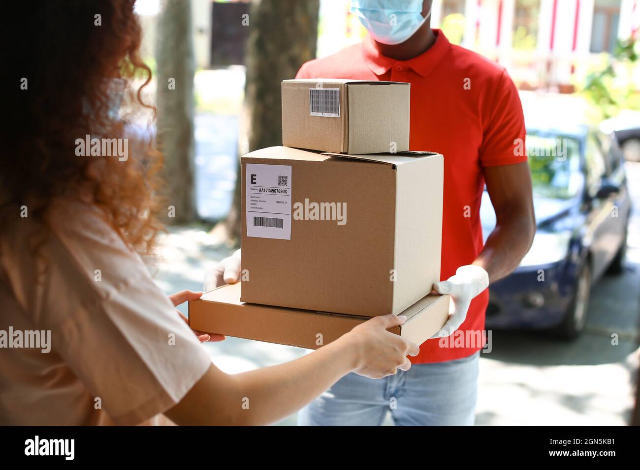 Customer receiving parcel from delivery man Stock Photo - Alamy