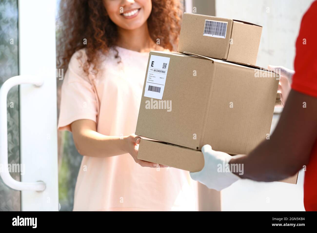 Customer receiving parcel from delivery man Stock Photo - Alamy
