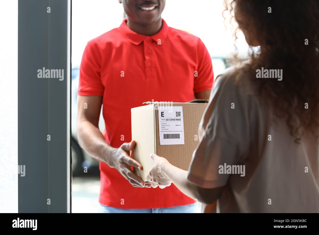 Customer receiving parcel from delivery man Stock Photo - Alamy