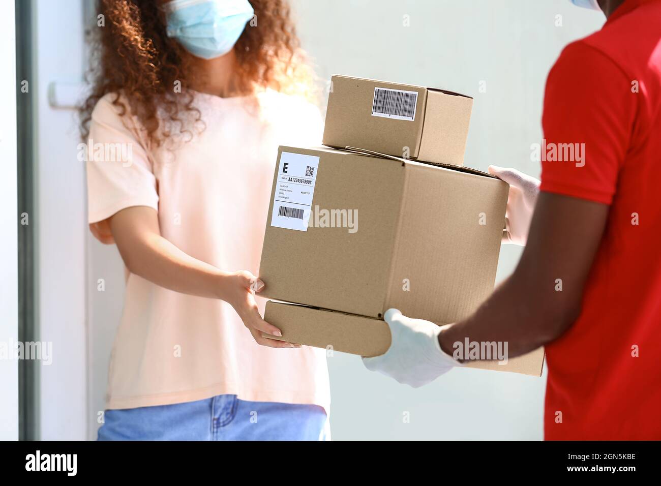 Customer receiving parcel from delivery man Stock Photo - Alamy