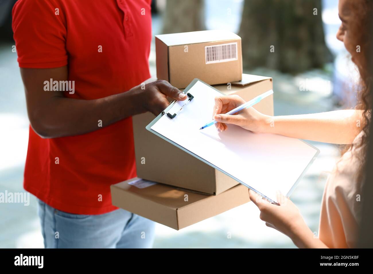 Customer receiving parcel from delivery man Stock Photo - Alamy