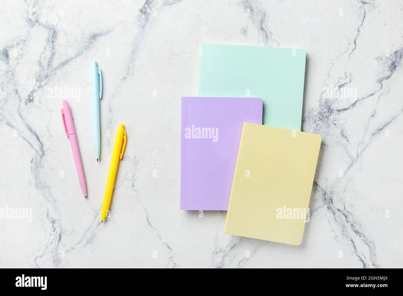 Stylish notebooks and pens on color background Stock Photo - Alamy
