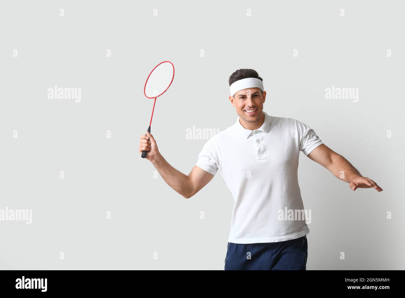 Sporty male badminton player on light background Stock Photo - Alamy