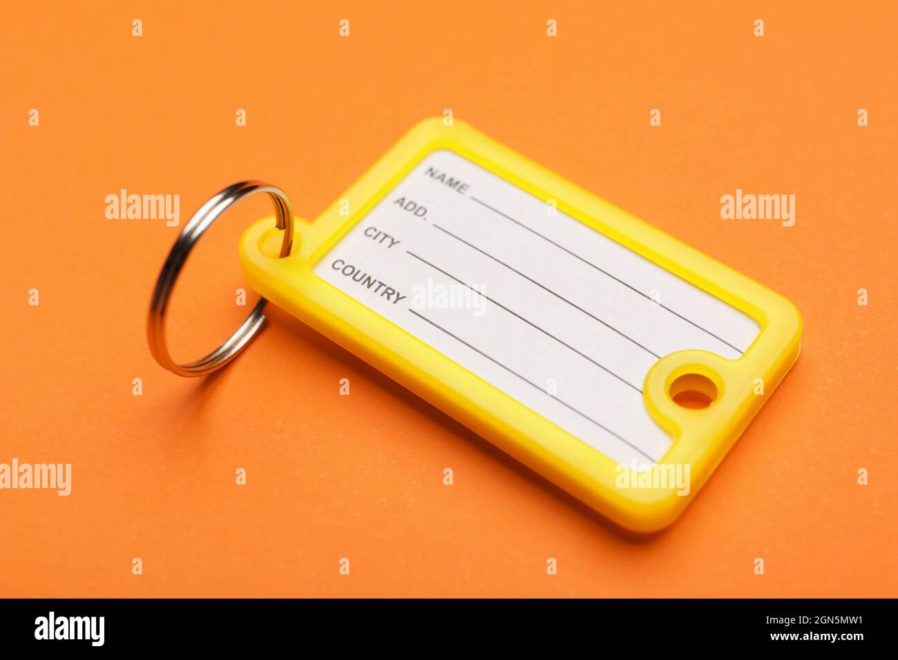 New plastic key tag on orange background Stock Photo - Alamy